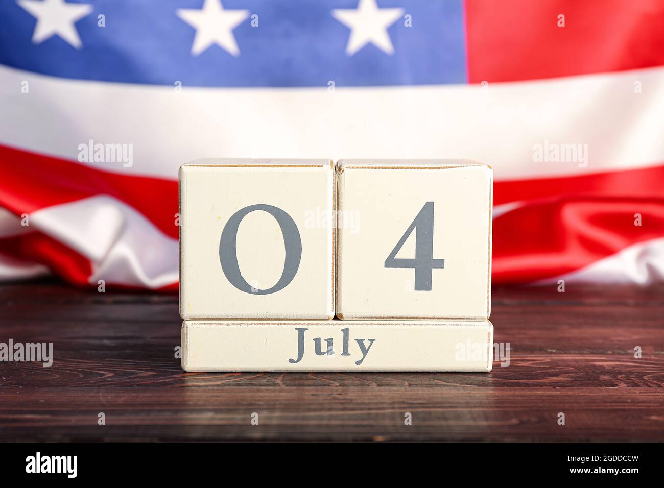 Calendar with date of Independence Day on table against American flag ...
