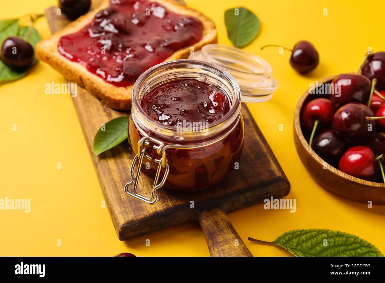 Jar and toast with cherry jam on color background Stock Photo - Alamy