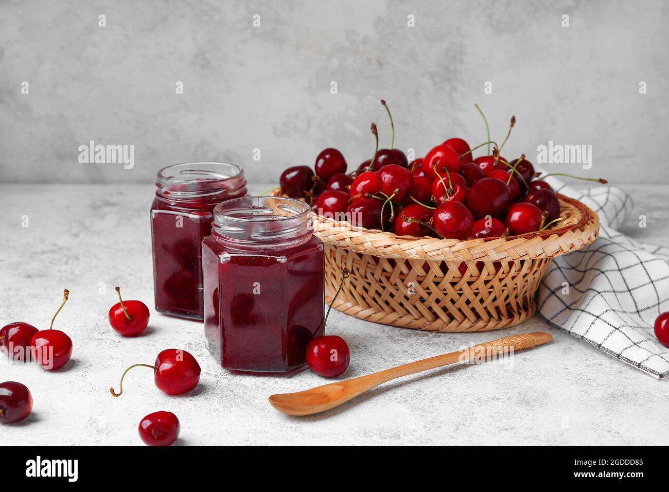 Composition with sweet cherry jam on light background Stock Photo - Alamy