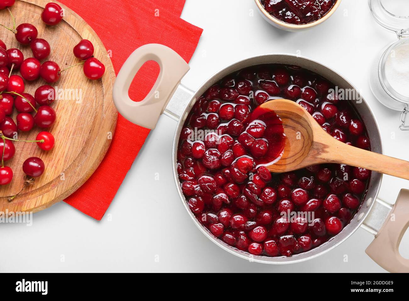 Composition with tasty cherry jam on white background Stock Photo - Alamy