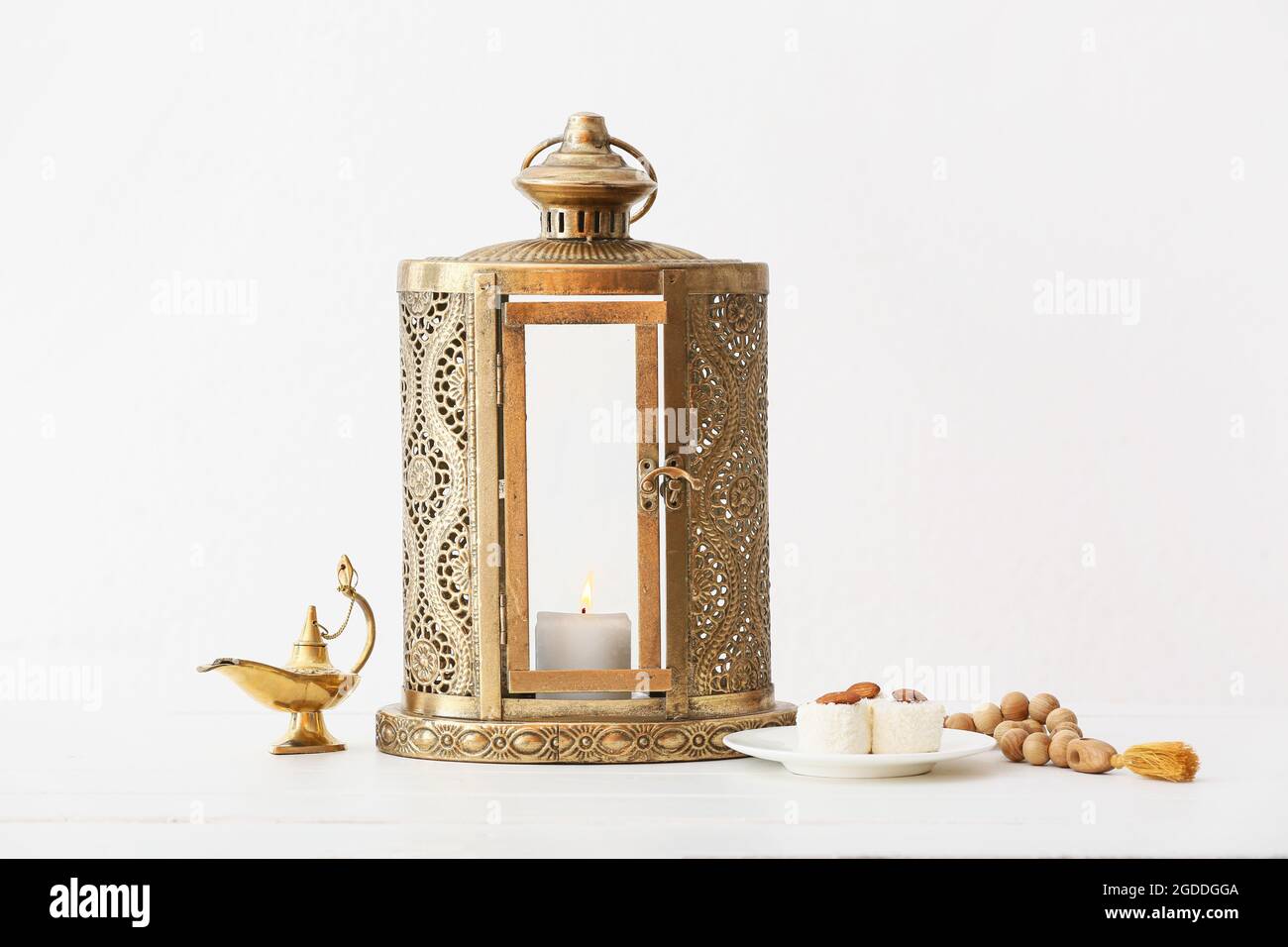 Muslim lantern with Aladdin lamp, tasbih and Turkish sweets on light ...
