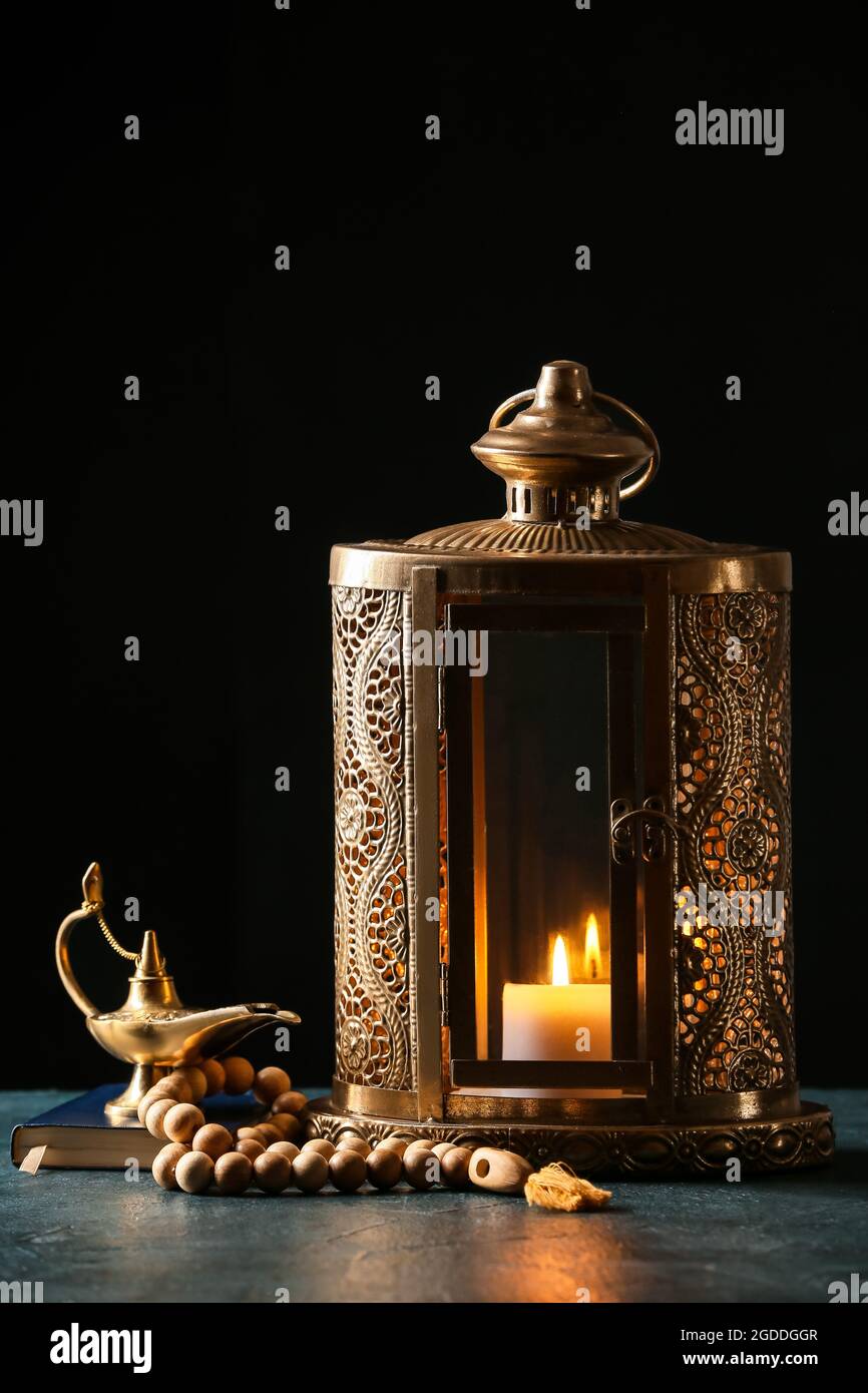 Muslim lantern with Quran, Aladdin lamp and tasbih on dark background ...