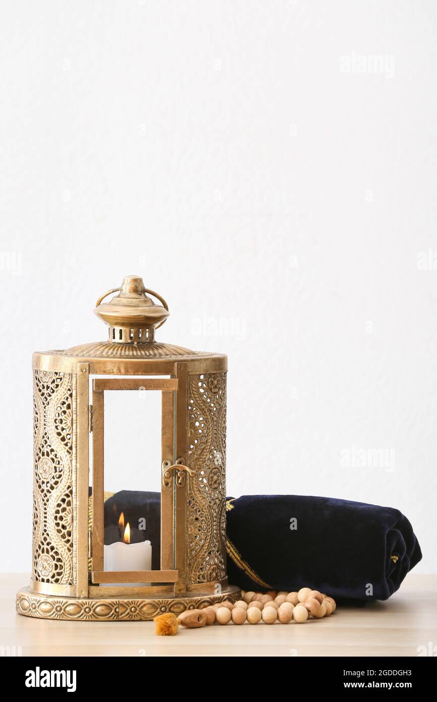 Muslim lantern with prayer rug and tasbih on light background Stock ...