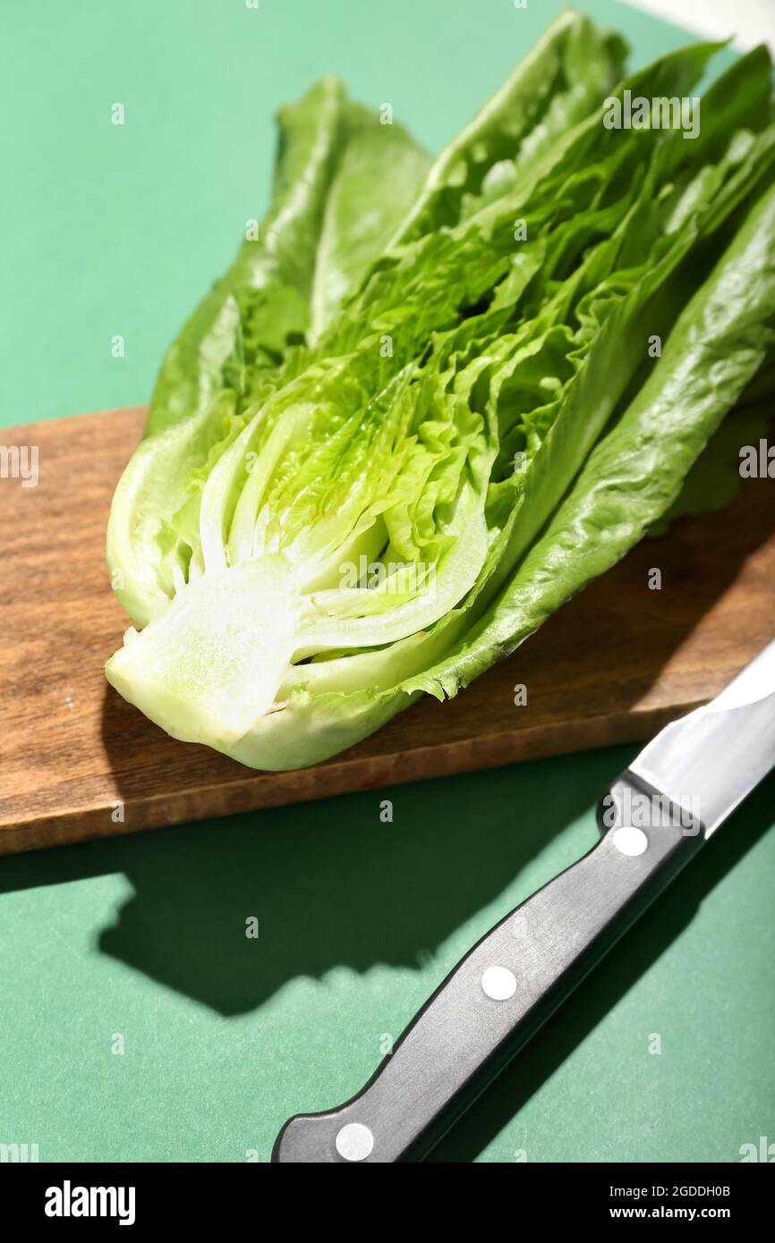 Board with fresh romaine lettuce on color background, closeup Stock ...