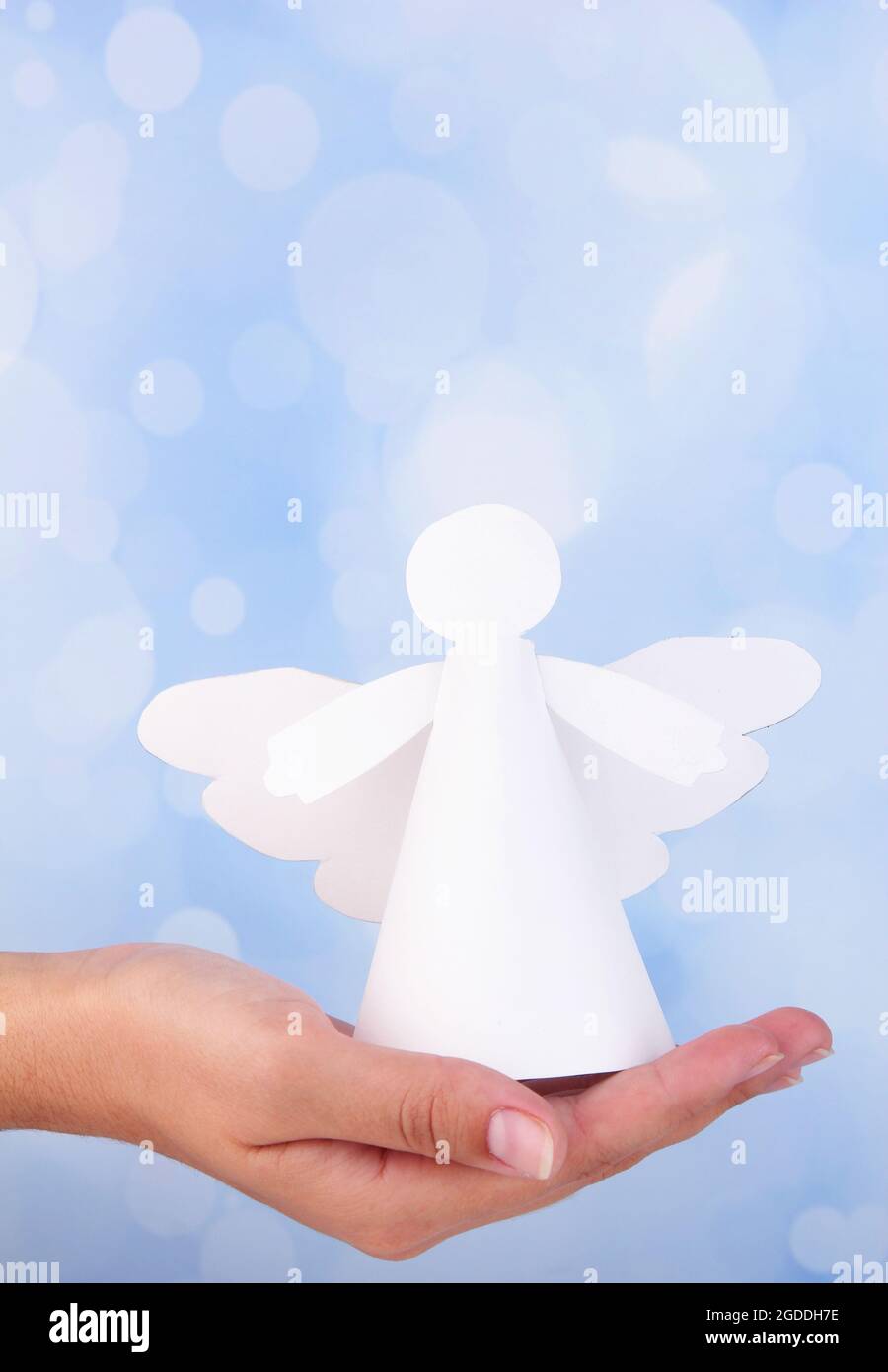 Christmas angel in hand on bright background Stock Photo - Alamy