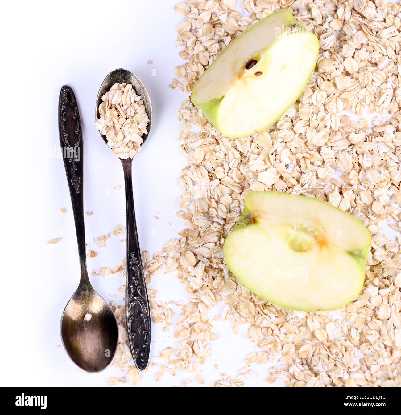 Apple with oatmeal and vintage spoons, isolated on white Stock Photo ...
