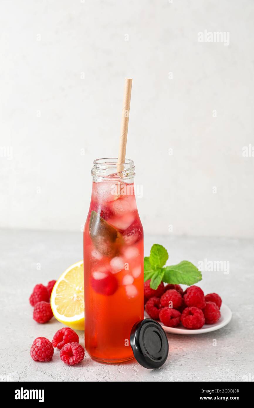 Bottle with tasty raspberry lemonade on light background Stock Photo ...