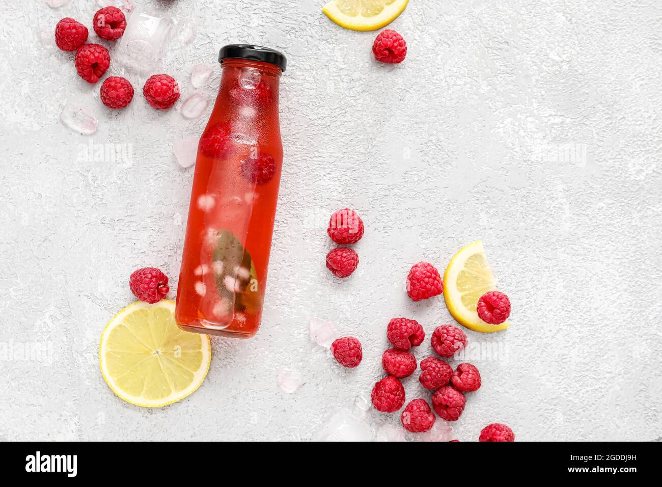 Bottle with tasty raspberry lemonade on light background Stock Photo ...