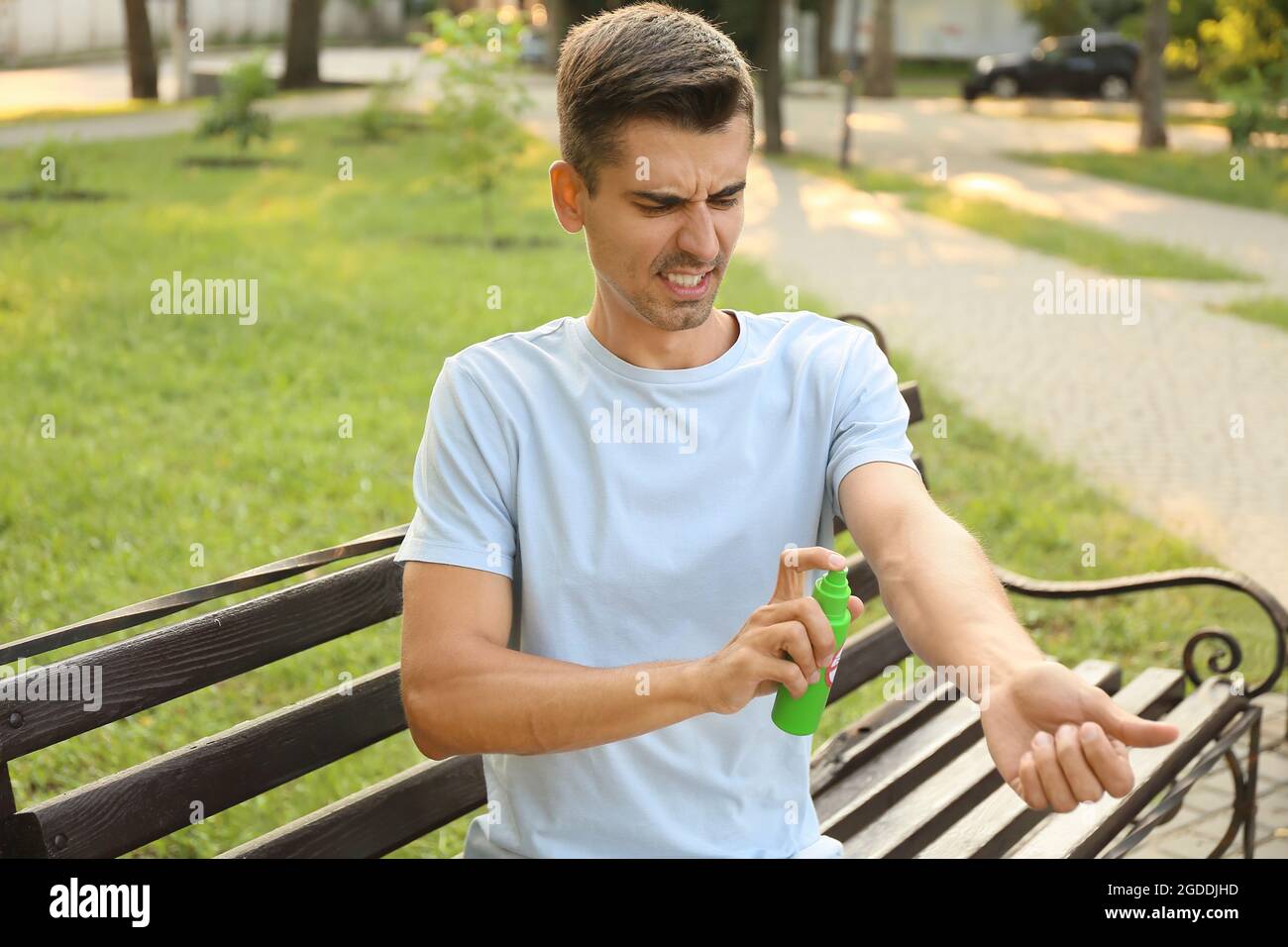 Young man with mosquito repellent outdoors Stock Photo - Alamy