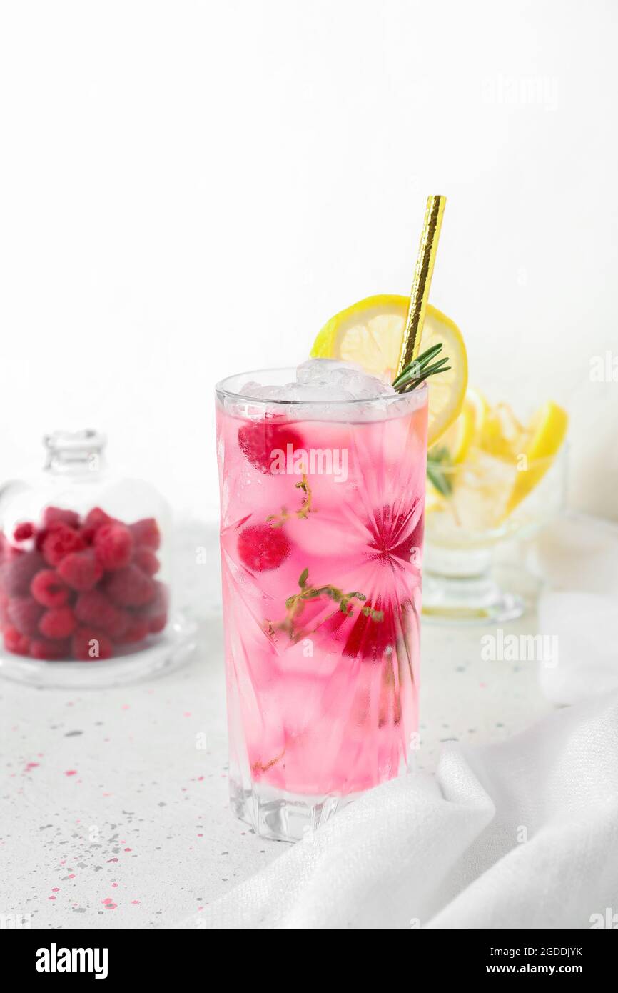Glass of tasty raspberry lemonade on light background Stock Photo - Alamy