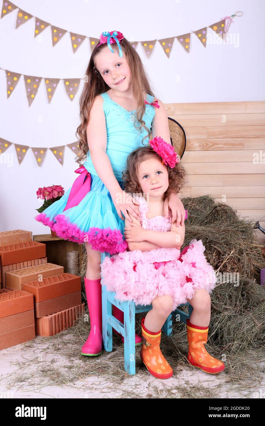 Beautiful small girls in petty skirts on country style background Stock ...