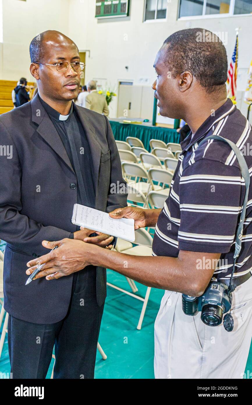 Black man male priest haitian newspaper journalist reporter interviews interviewing hi-res stock ...