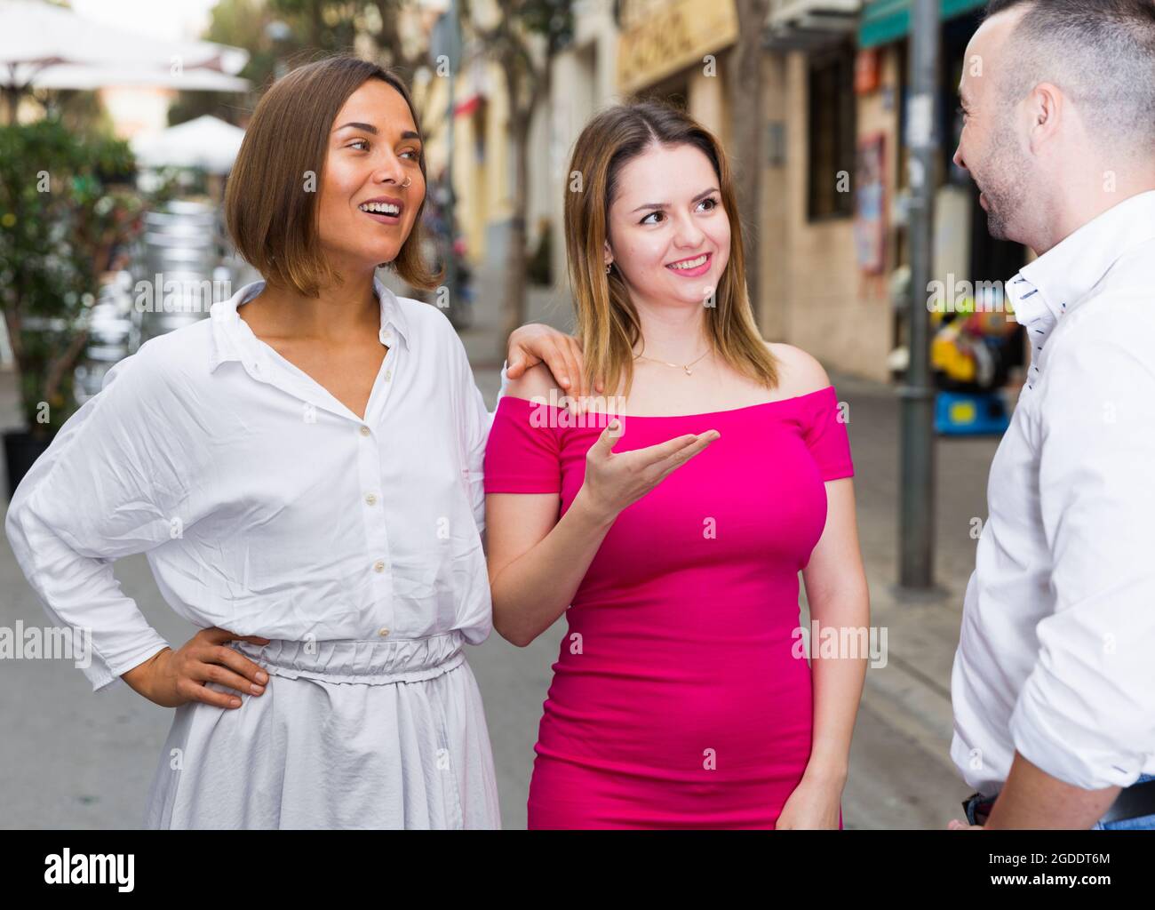 Young male is acquaintance with girls who are walking Stock Photo - Alamy