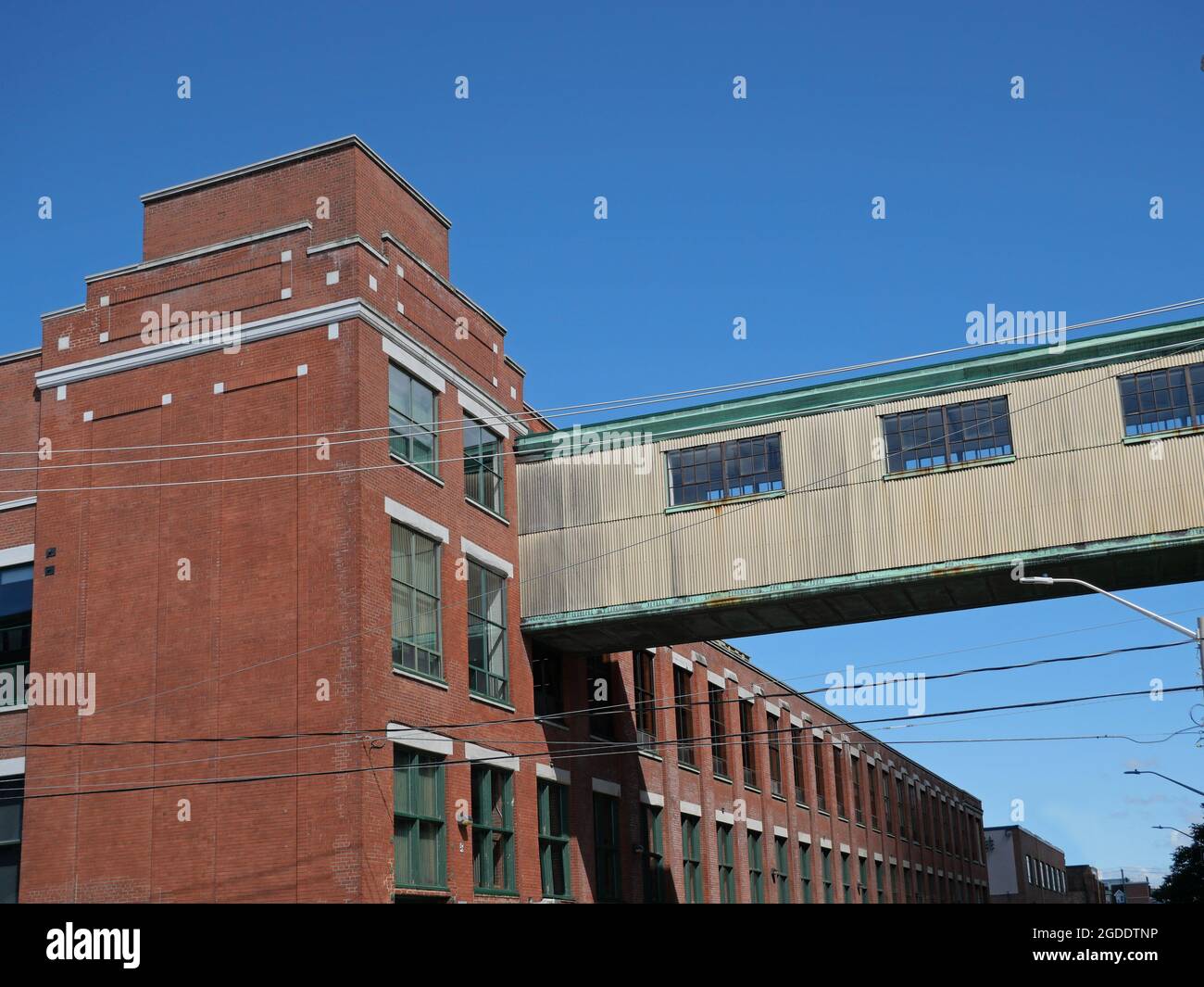 Large old brick factory building with catwalk connecting it to a ...