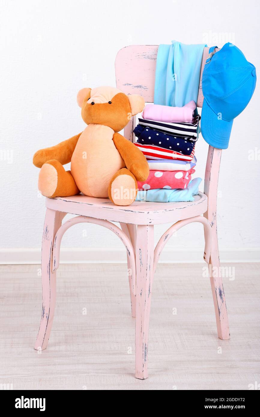 Clothes on chair on gray wall background Stock Photo - Alamy