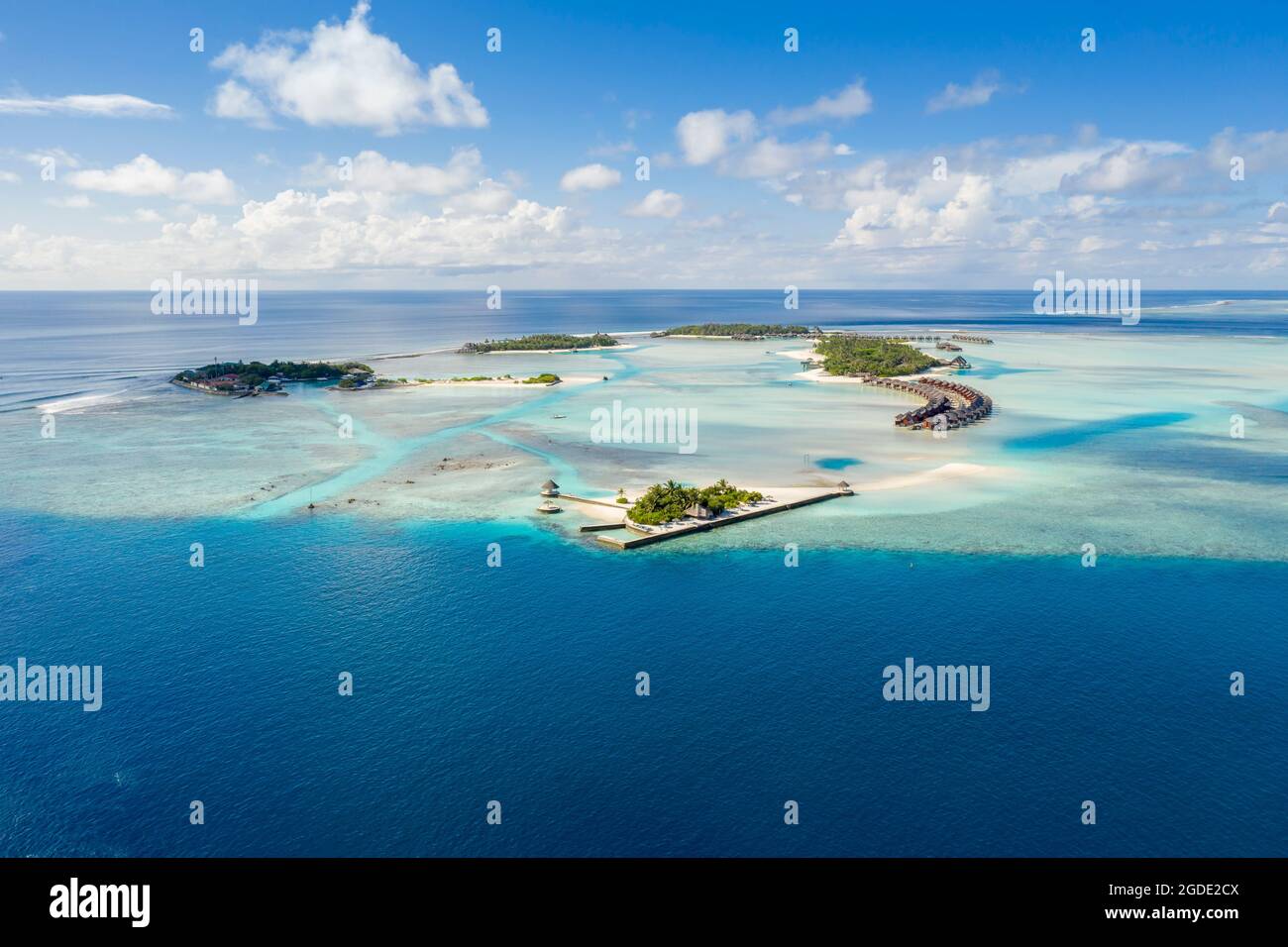 Aerial view of a coral atoll with tropical islands with palm trees in ...