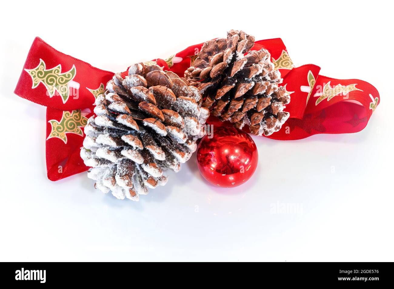 Christmas pine cones with red ornament and red bow isolated on white ...