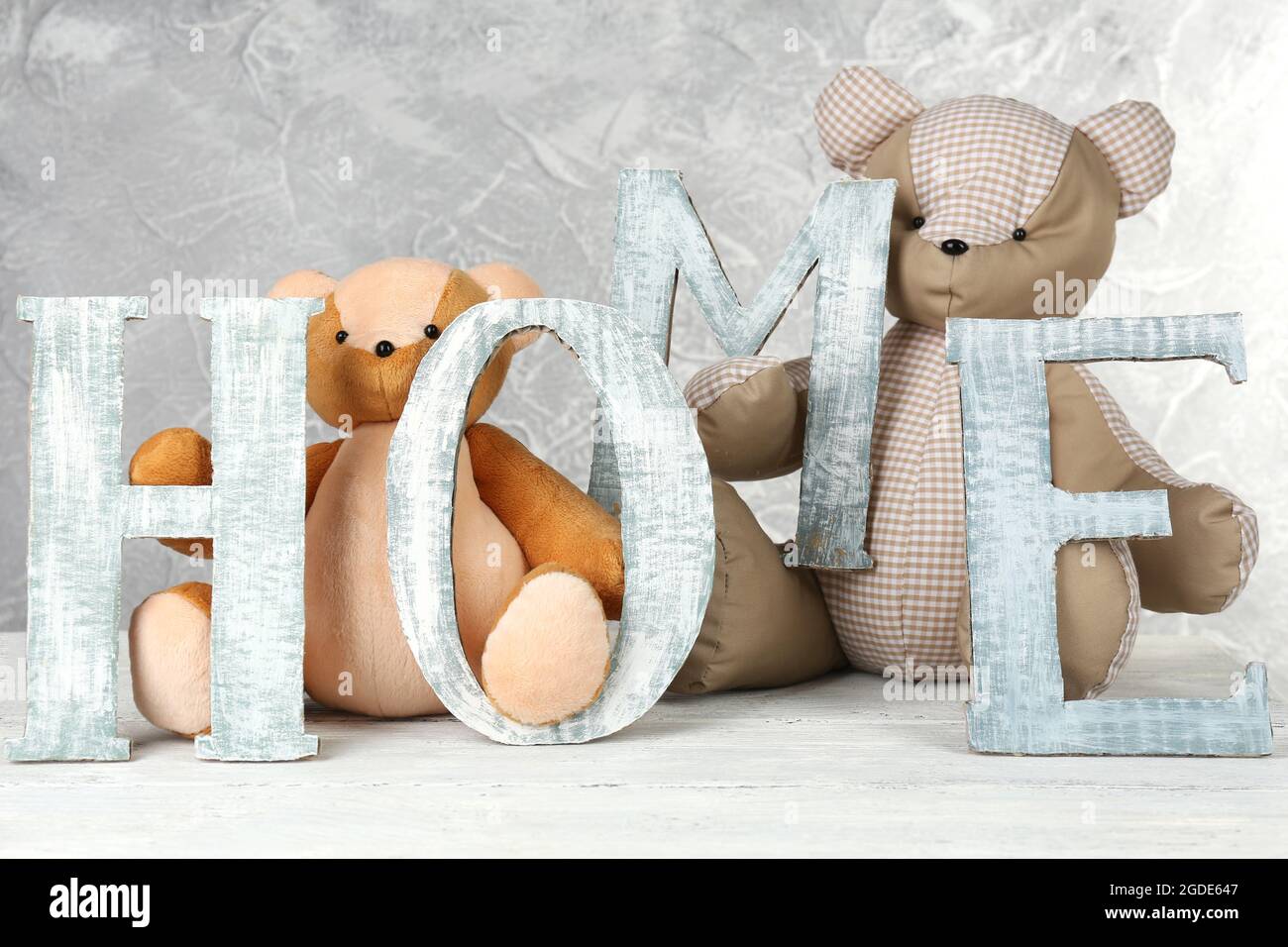 Decorative letters forming word HOME with teddy bear on grey background ...