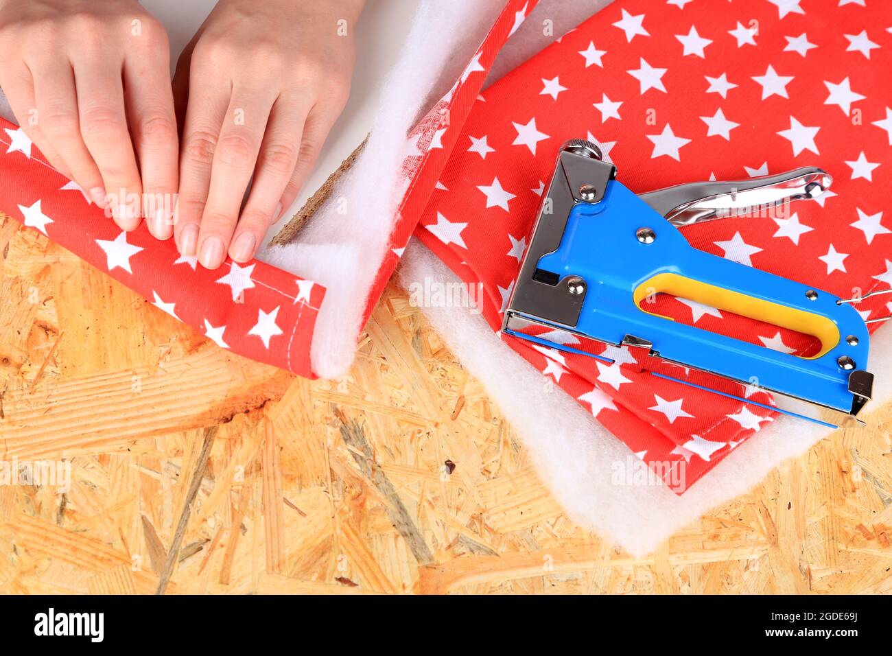 Fastening fabric and board using construction stapler Stock Photo - Alamy