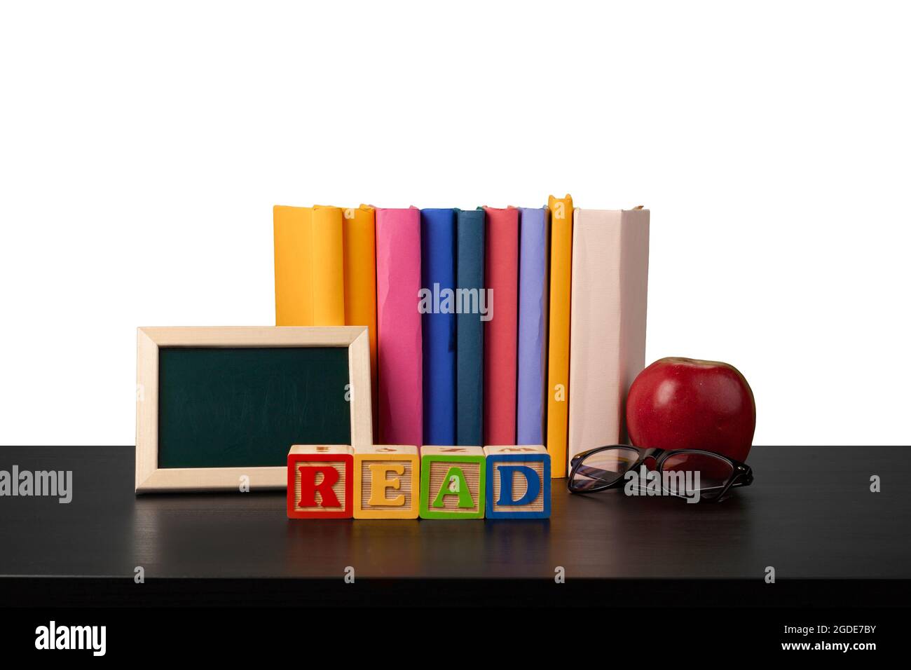Stack of books and apple on tabletop against white background Stock ...