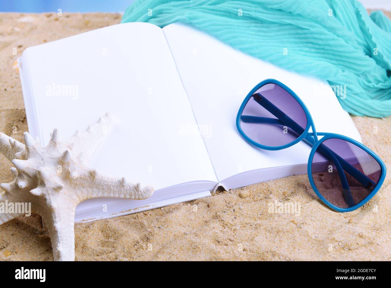 Open white book on sand background Stock Photo - Alamy