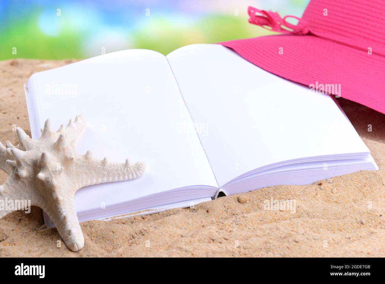 Open white book on sand background Stock Photo - Alamy
