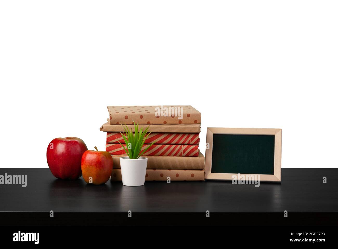 Stack of books and apple on tabletop against white background Stock ...