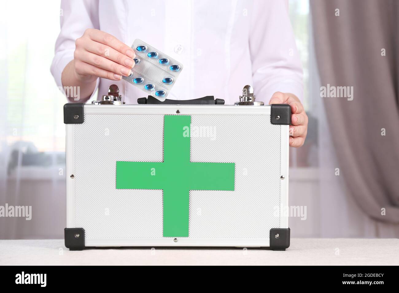 Nurse holding first aid kit in room Stock Photo - Alamy
