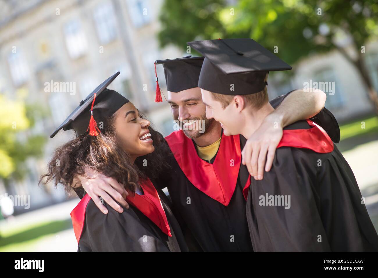 Smiling graduates hugging outdoors hi-res stock photography and images ...