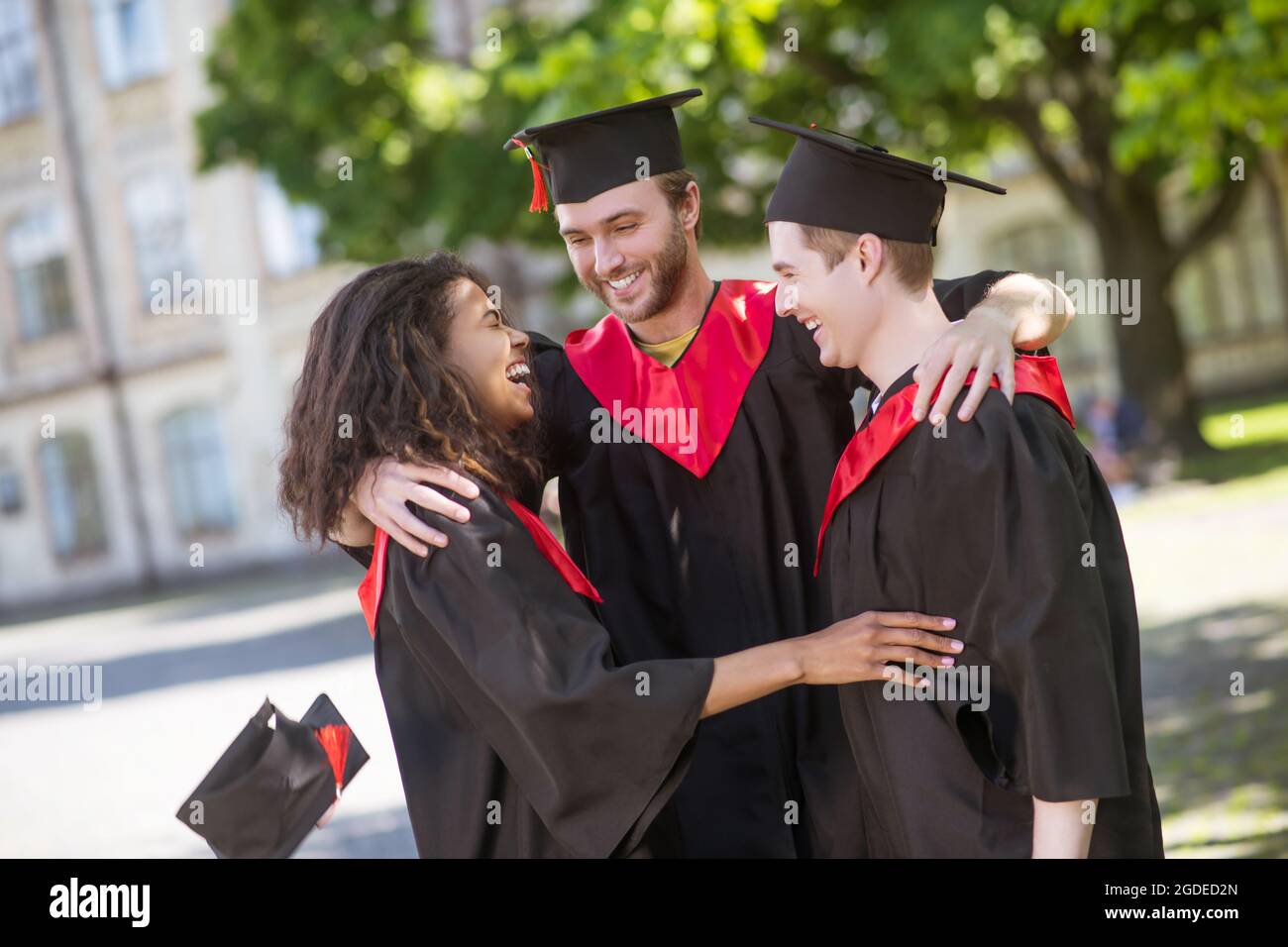 Smiling graduates hugging outdoors hi-res stock photography and images ...