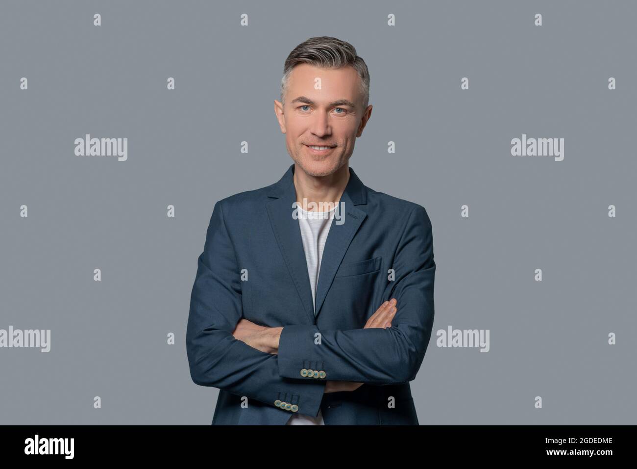 Man in jacket with his arms folded across chest Stock Photo - Alamy