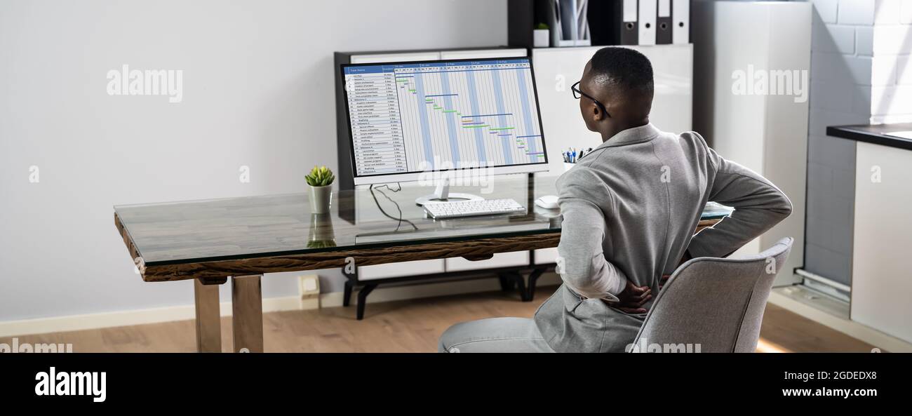 Back Pain Bad Posture At Office Desk Stock Photo - Alamy
