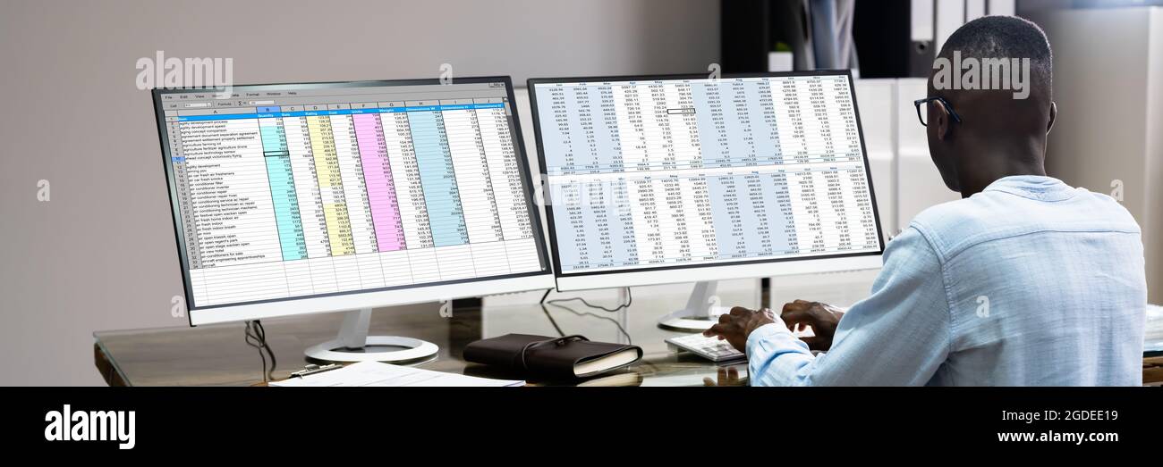 African Data Analyst Man Using Spreadsheet On Computer Stock Photo - Alamy