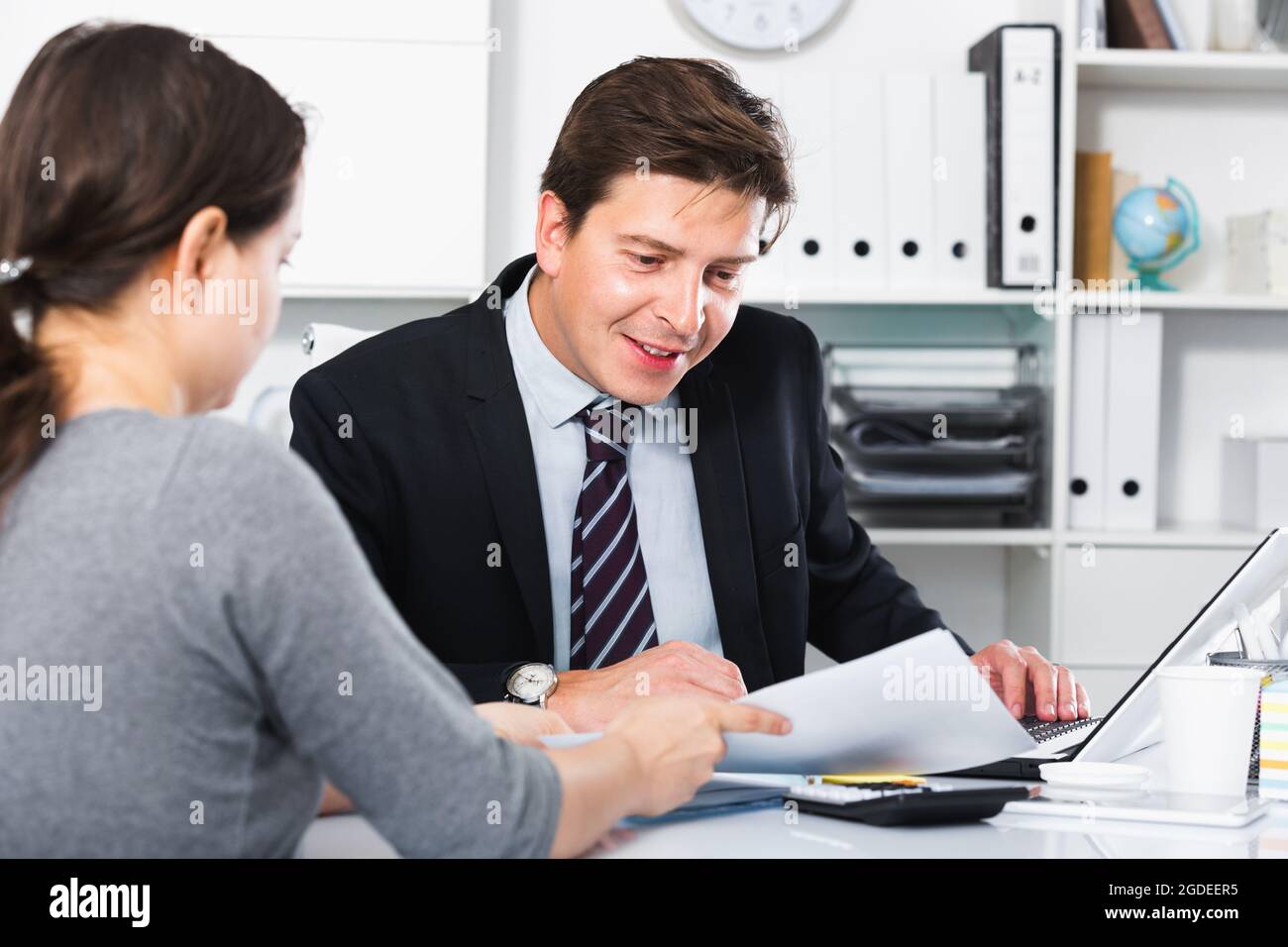 Young male speaking with female in the office Stock Photo - Alamy