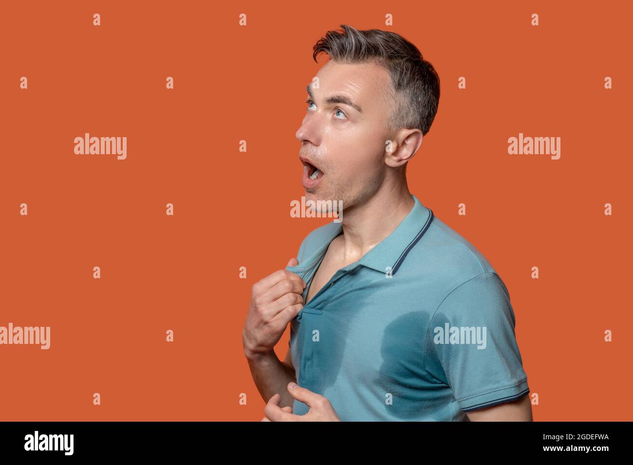 Sad man suffering from heavy sweating Stock Photo - Alamy