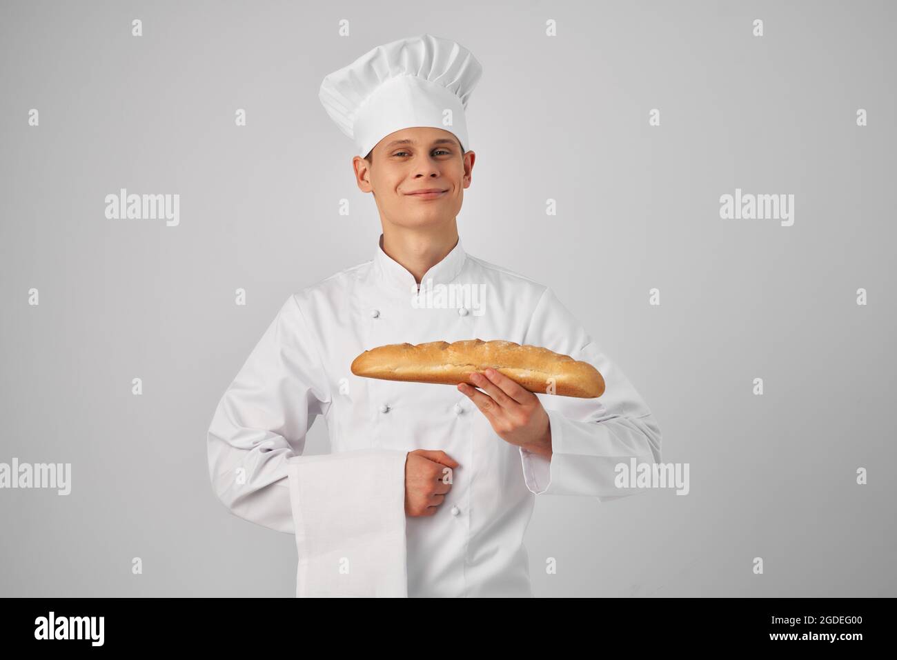 a man in chef's clothes Holding a loaf baker Professional Stock Photo ...