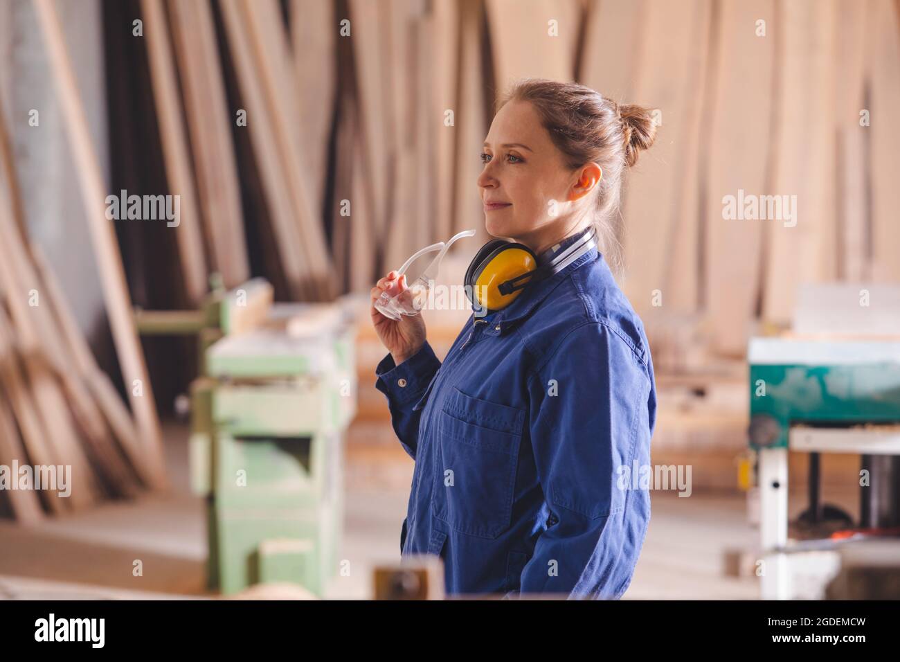 Cheerful female production operator in blue coverall Stock Photo - Alamy