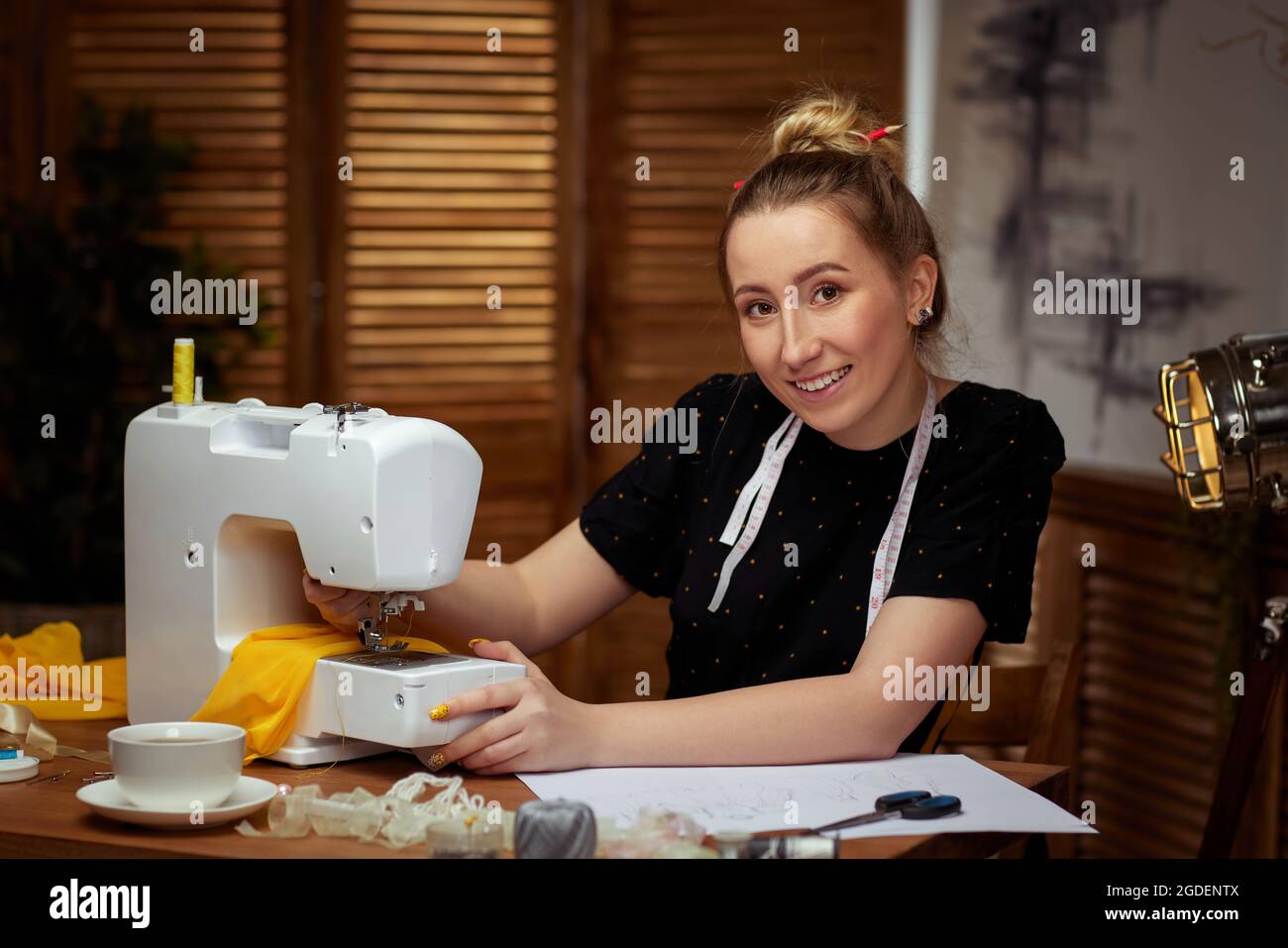 Beautiful young seamstress working on sewing machine Stock Photo - Alamy