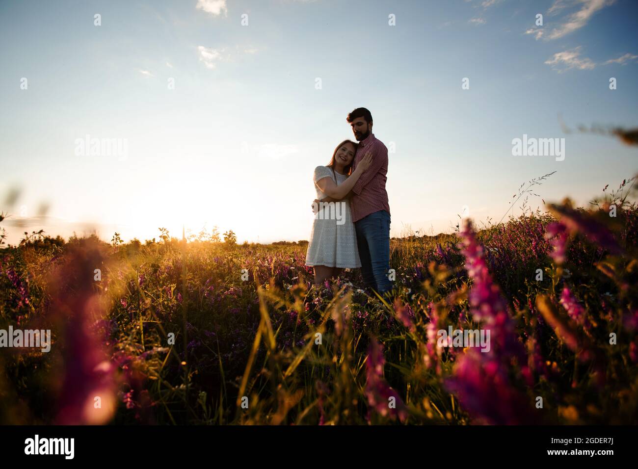 Romantic couple love moment in field among wild flowers Stock Photo - Alamy