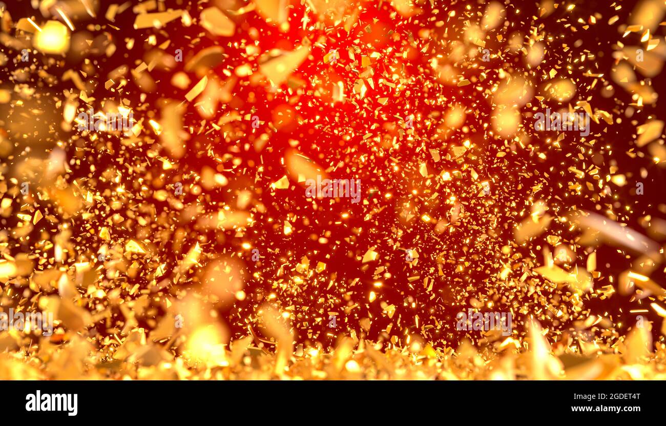 explosion of gold metallic fragments on a red background, selective ...