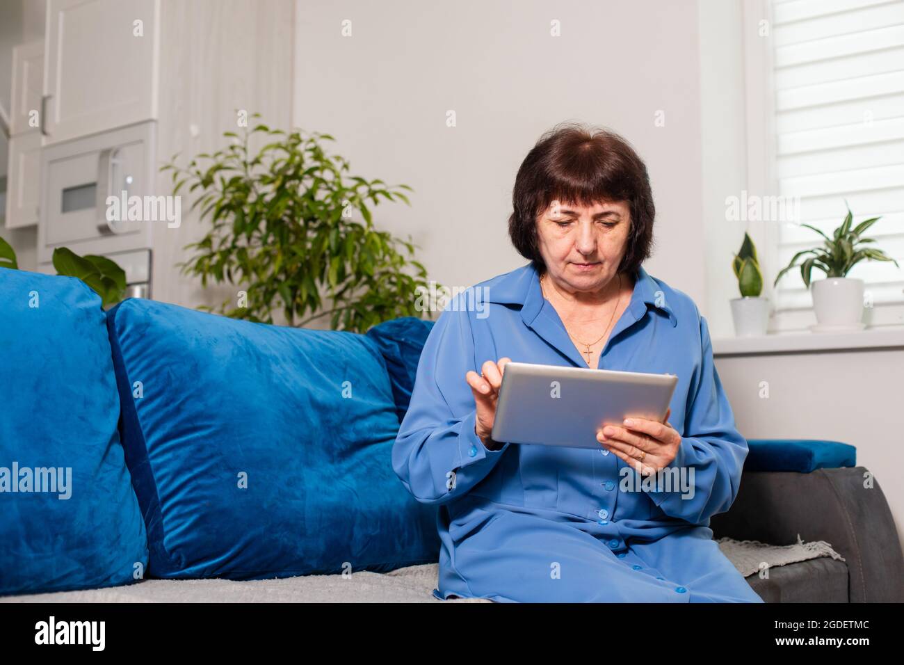 Relaxed mature woman holding tablet using healthcare application Stock ...