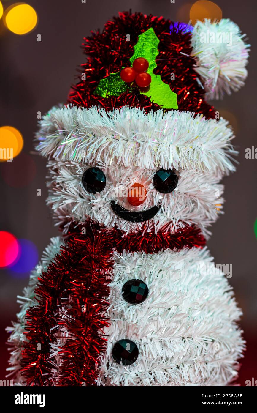 Vertical shot of snowman against colorful bokeh lights background Stock Photo - Alamy