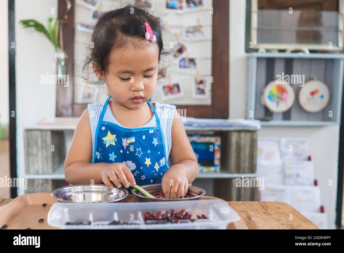 Cute little Thai girl cooking at a kindergaten Stock Photo - Alamy