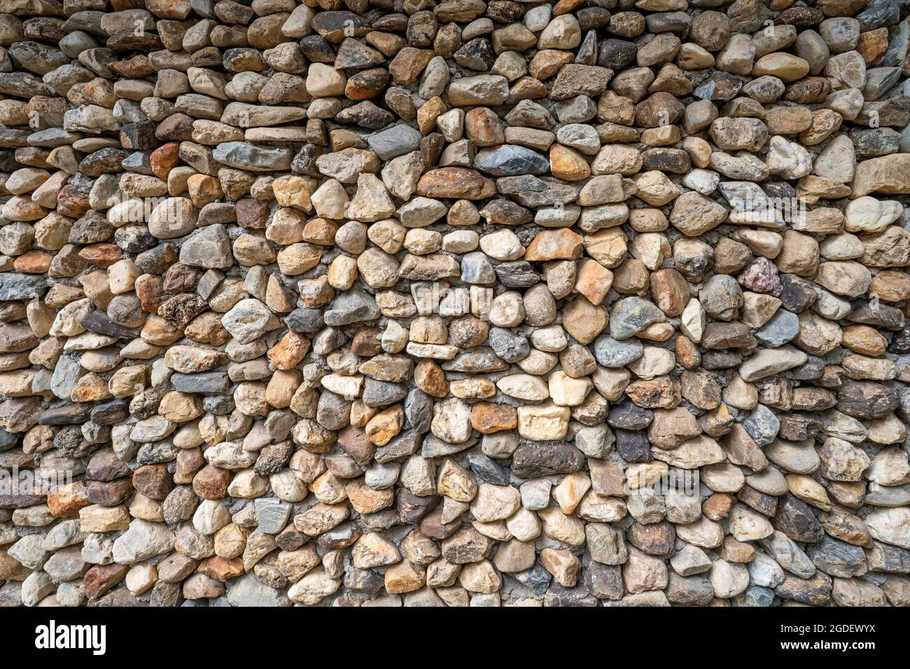 Stone wall made of pebbles Stock Photo - Alamy