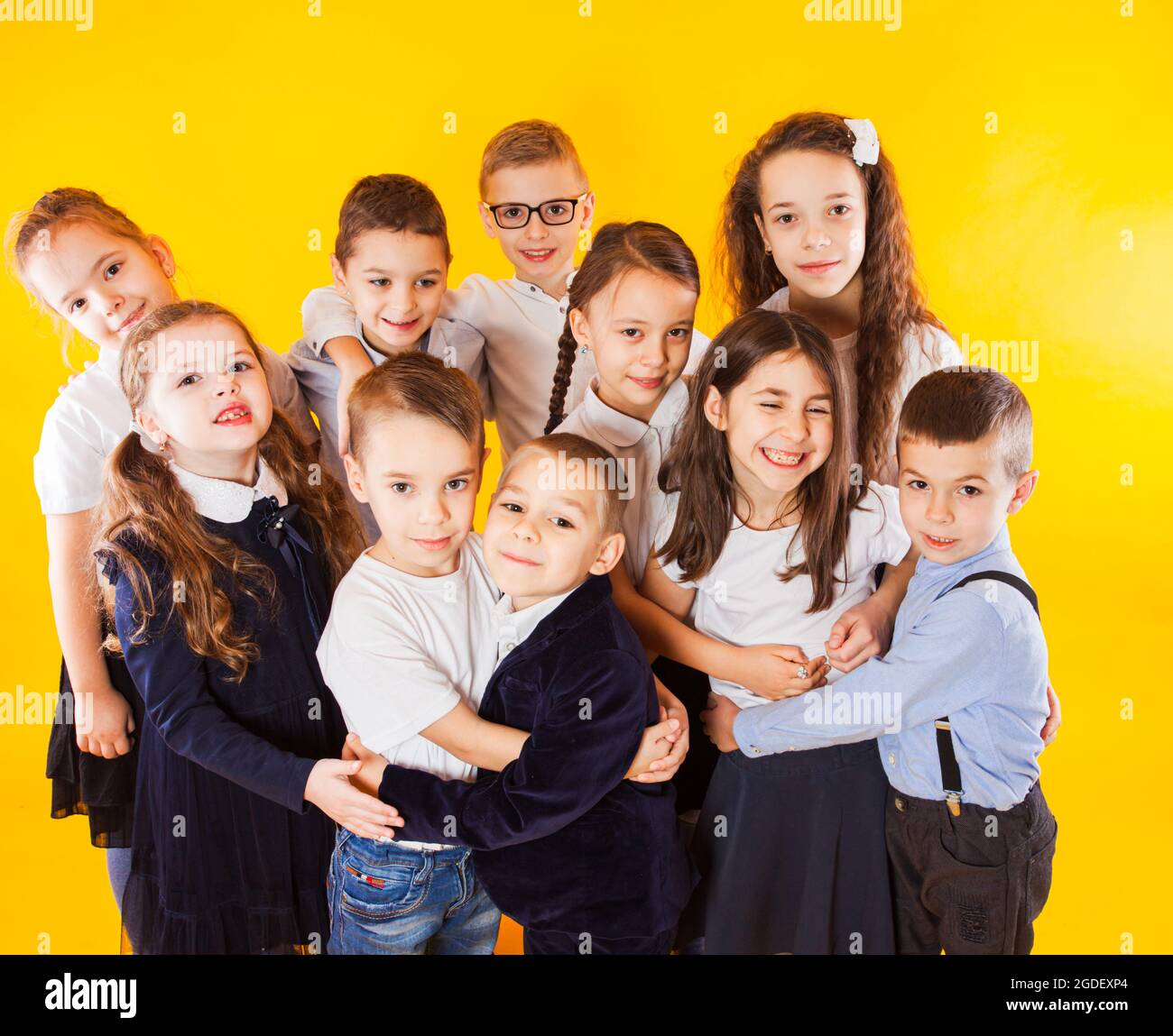 The friendly classmates are hugging on a yellow background Stock Photo ...