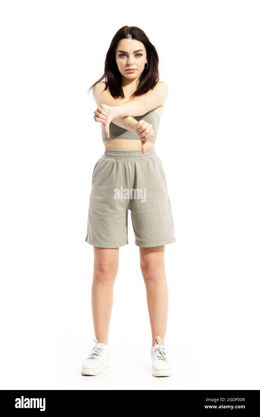 Bossy serious young cocky gen Z woman showing thumbs down gesture with ...