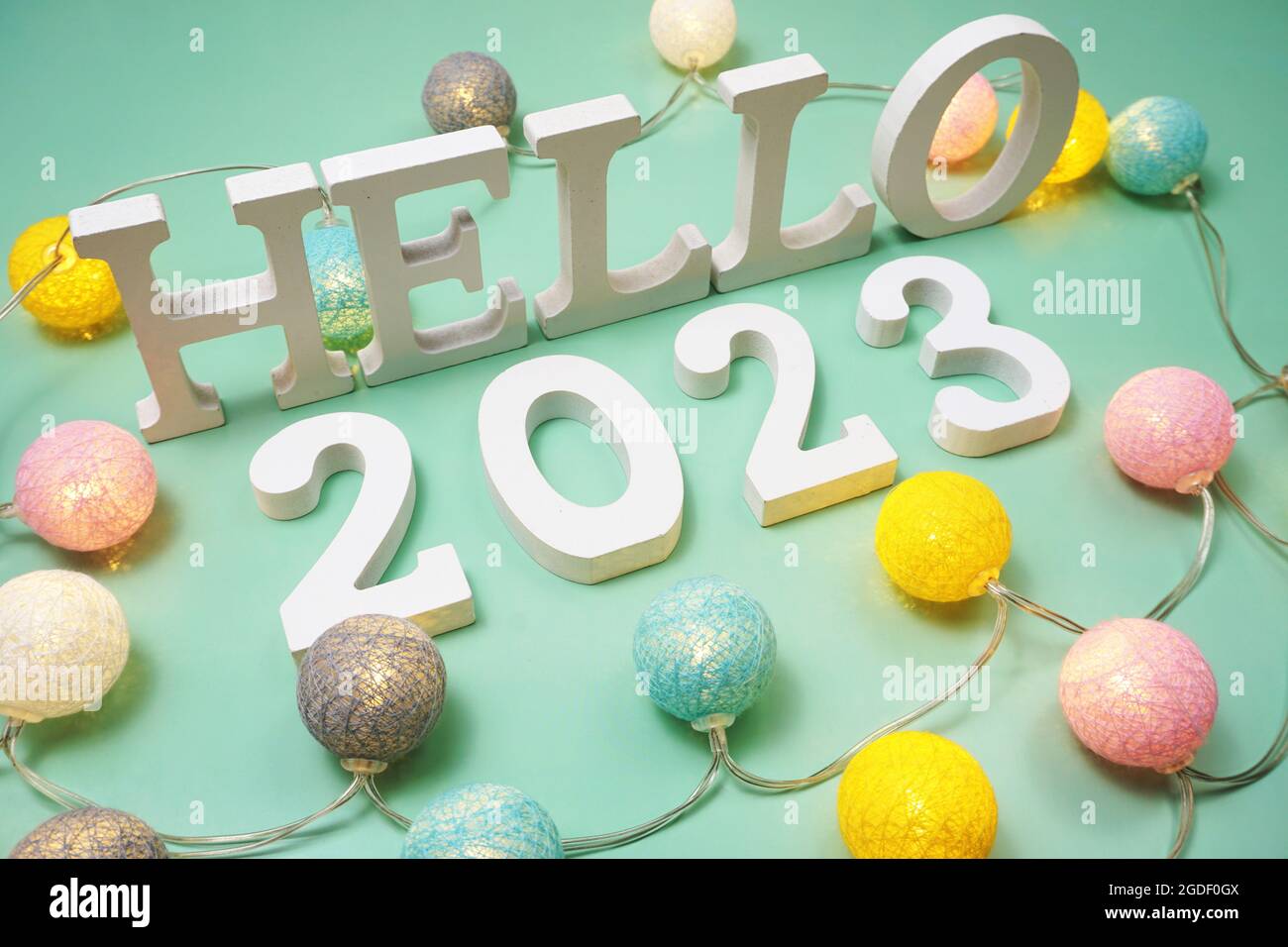 Hello 2023 alphabet letter with LED cotton balls on green background ...