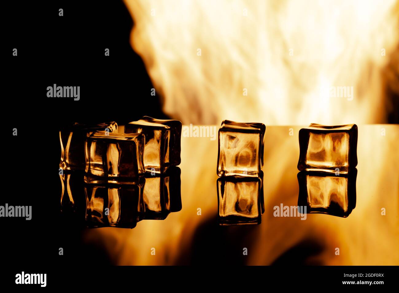 five ice cubes on a black background, in the background flames Stock ...