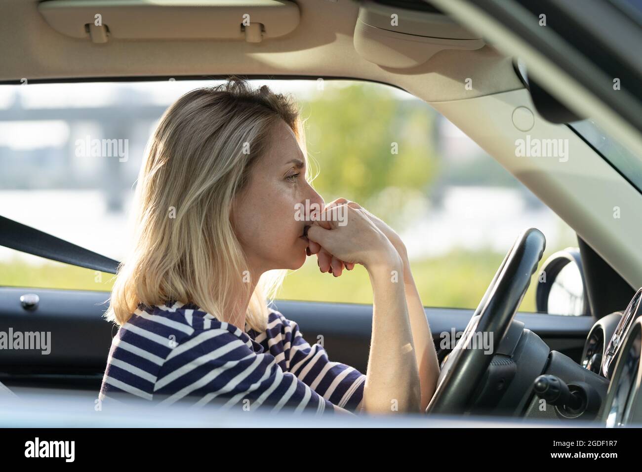 Serious anxious woman driving car. Female driver of middle age pensive ...