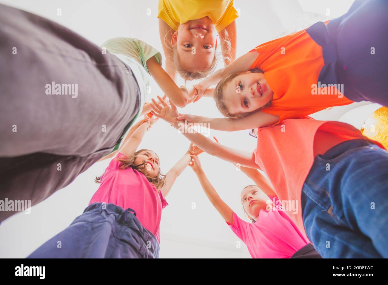 team of boys and girls are stacking hands together Stock Photo - Alamy